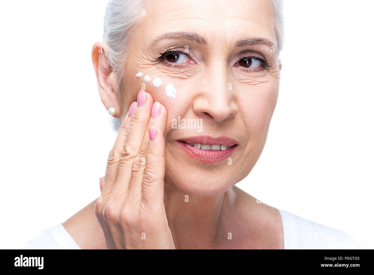 beautiful senior woman applying anti-wrinkle face cream, isolated on ... beautiful senior woman applying anti-wrinkle face cream, isolated on ...