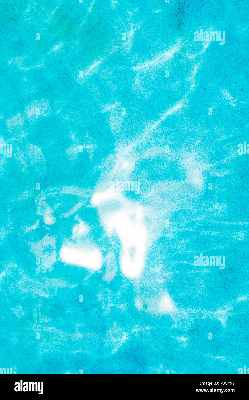 Reflected sunlight creates abstract patterns in outdoor swimming pool ...