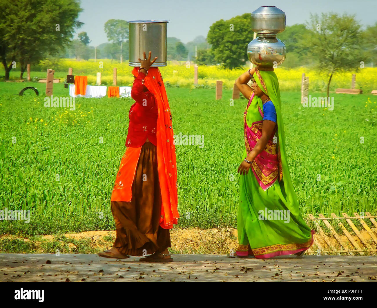 Woman carrying water bucket in hi-res stock photography and images - Alamy