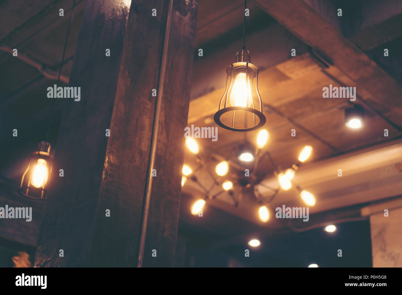 Decorative antique edison style light bulbs against cafe wall ...