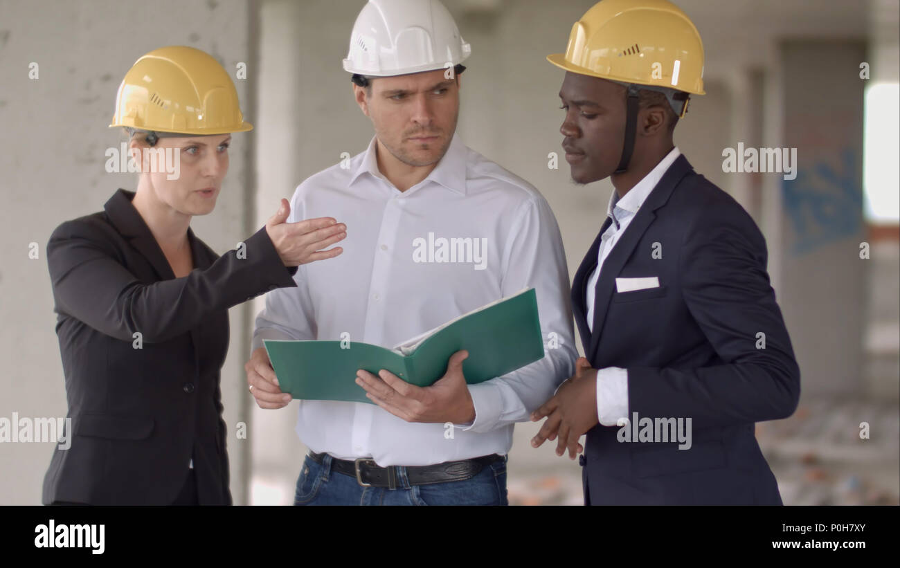 Team of architects comparing housing project with the building Stock ...