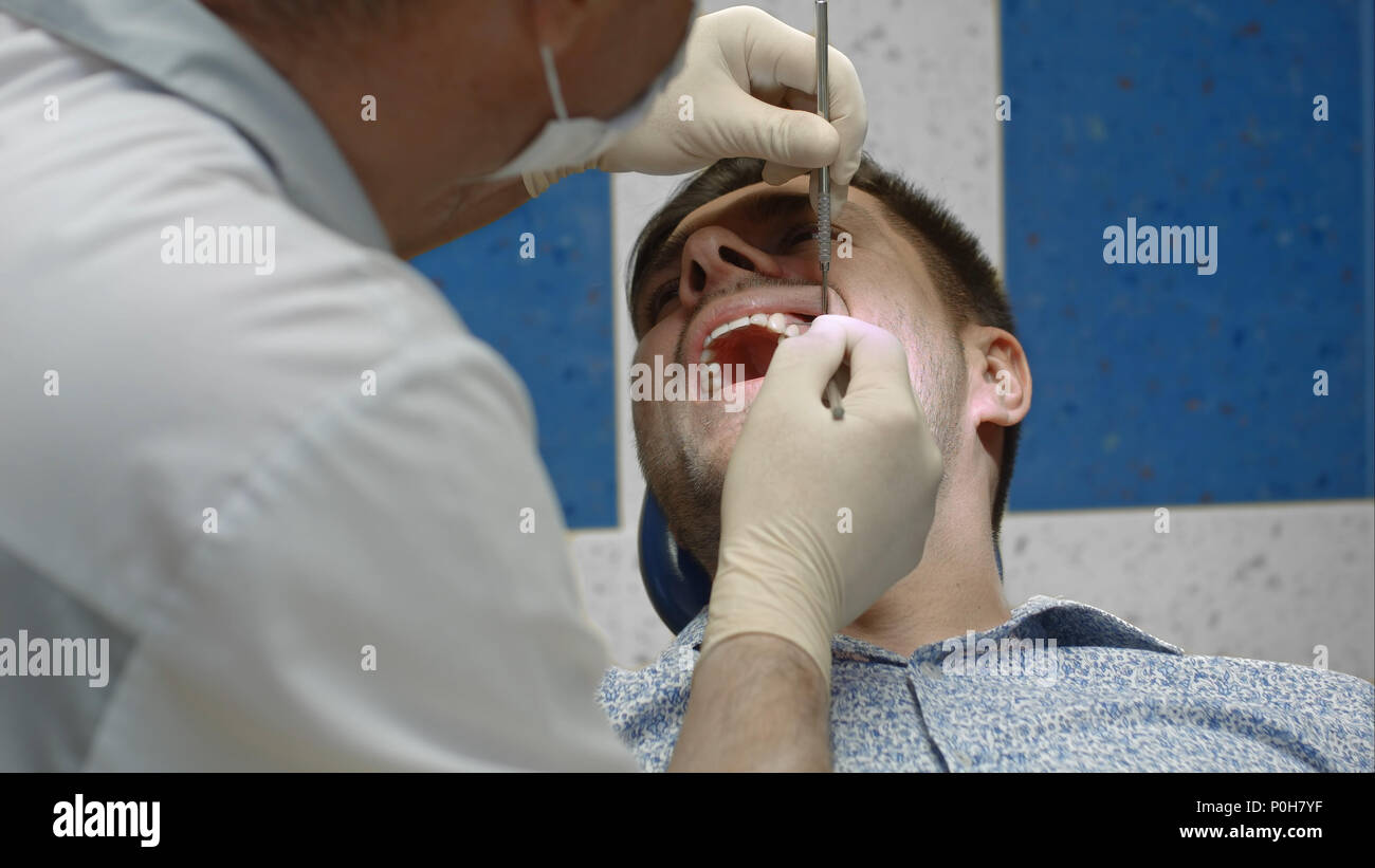 Dentist having view of client teeth Stock Photo - Alamy
