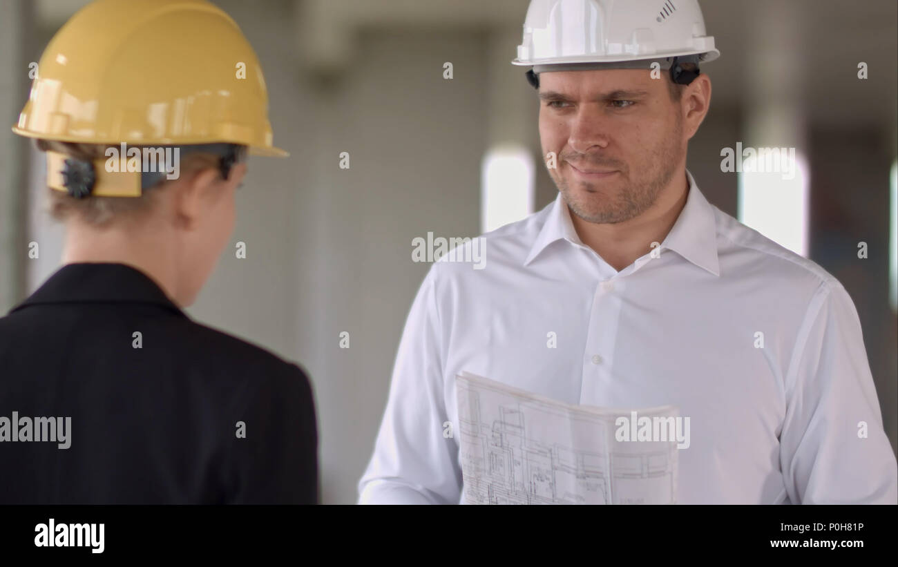 Handsome architect with supervisor of the construction site show place ...