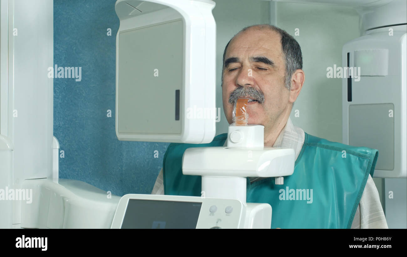Senior patient doing examination of teeth by using panoramic and ...