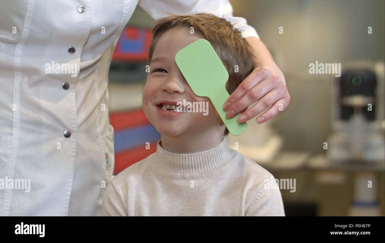 Boy looking at vision test with one eye covered with occluder Stock ...