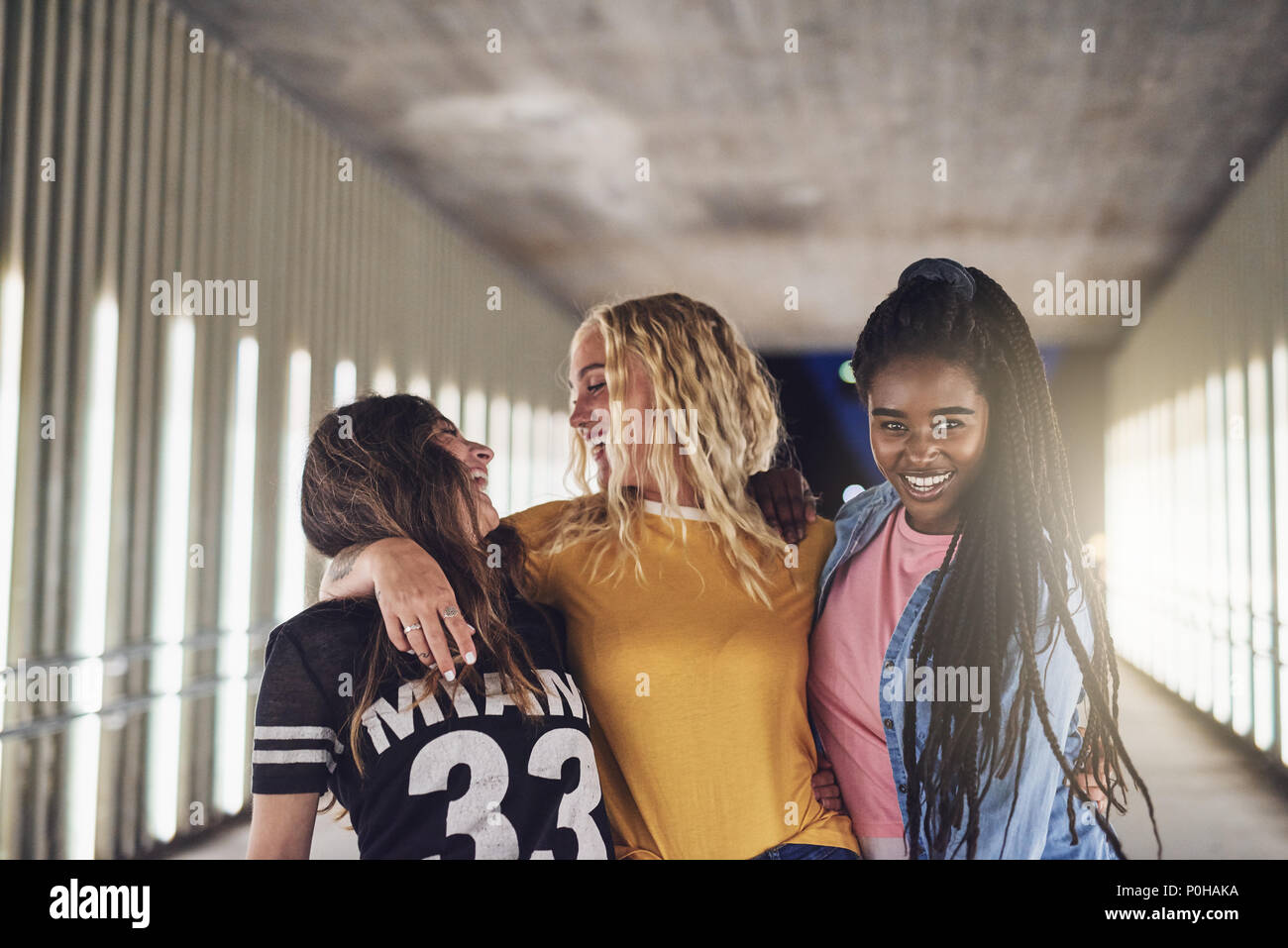 Diverse group of young girlfriends laughing and having fun while ...