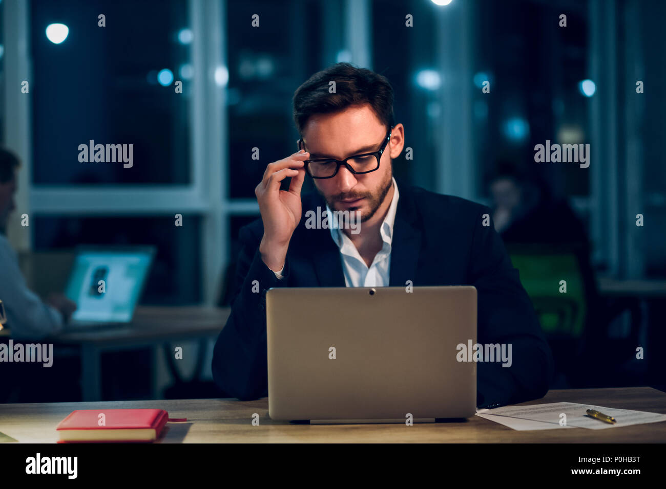 Young businessman staying up late working Stock Photo - Alamy