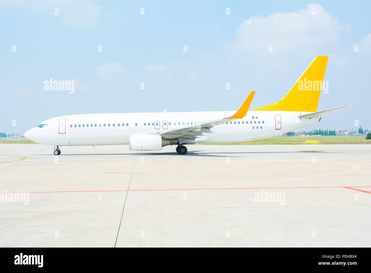 White passenger airplane on the airport runway. The plane is taking off ...