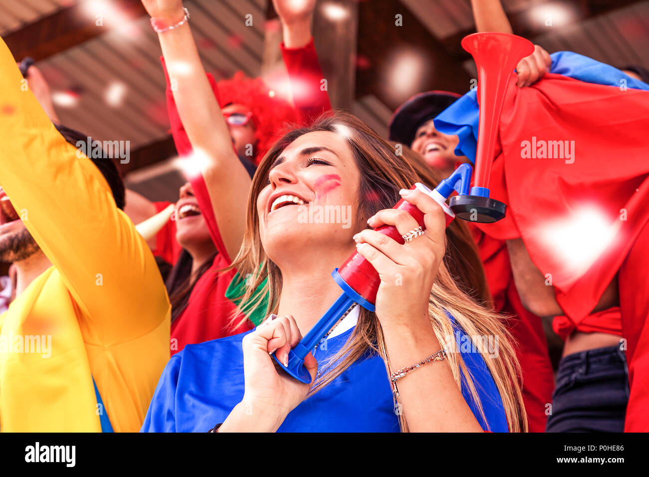group of fans dressed in various colors watching a sports event in the ...