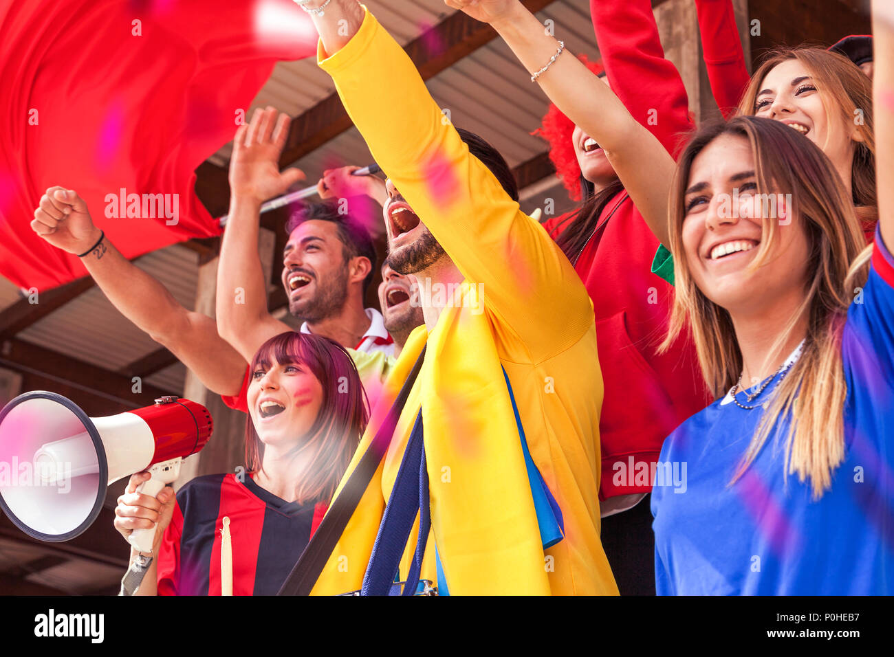 group of fans dressed in various colors watching a sports event in the ...