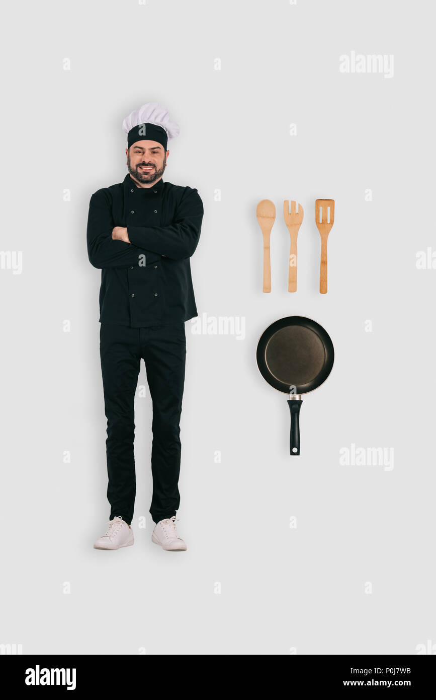 top view of male chef with frying pan and spatulas isolated on white ...