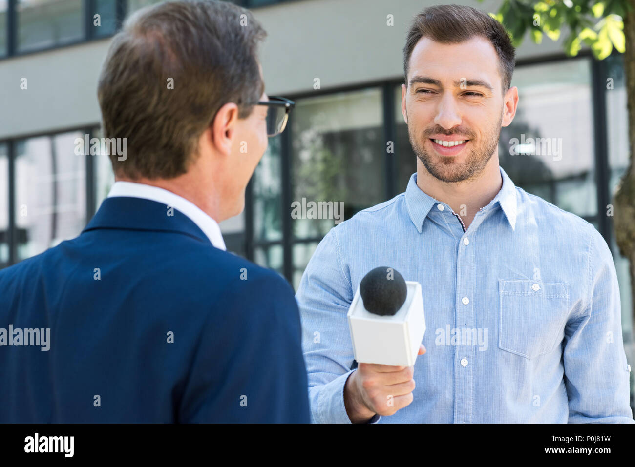 professional news reporter interviewing successful businessman with ...