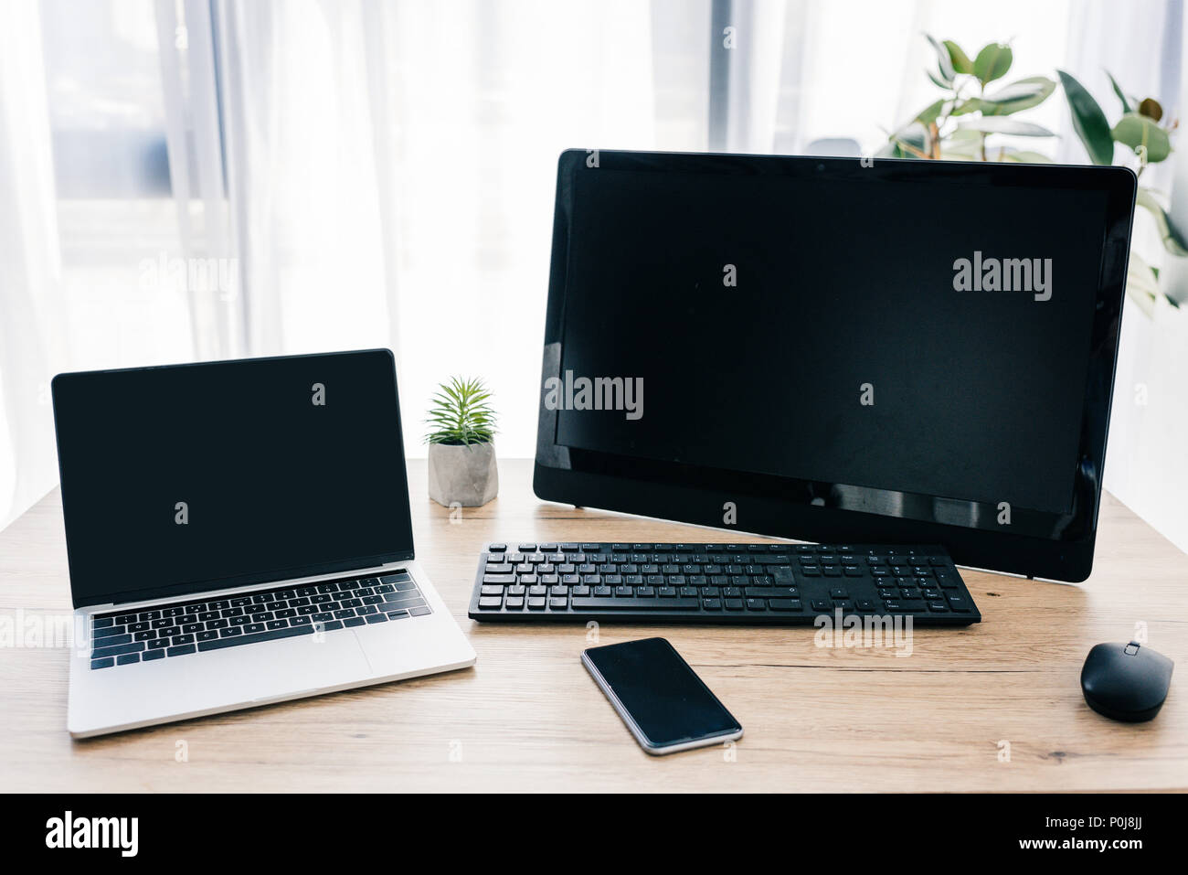 closeup shot of laptop with blank screen, computer, smartphone and ...