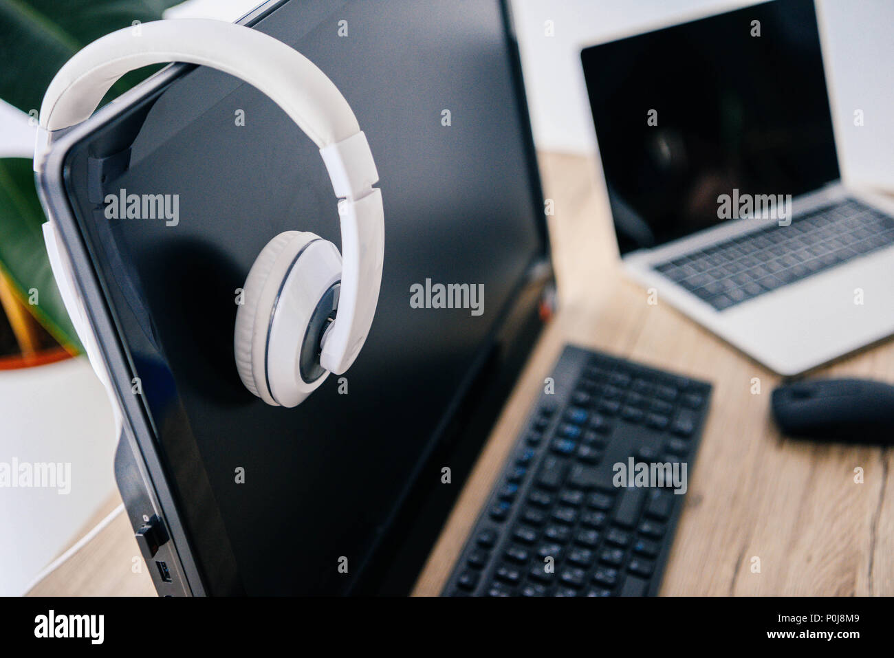 closeup view of headphones on computer and laptop at table Stock Photo ...