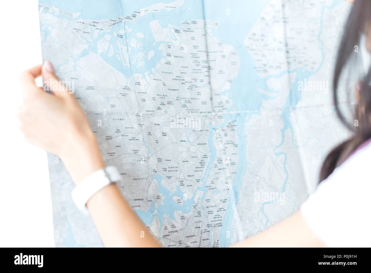 cropped view of female tourist holding map in hands, isolated on white ...