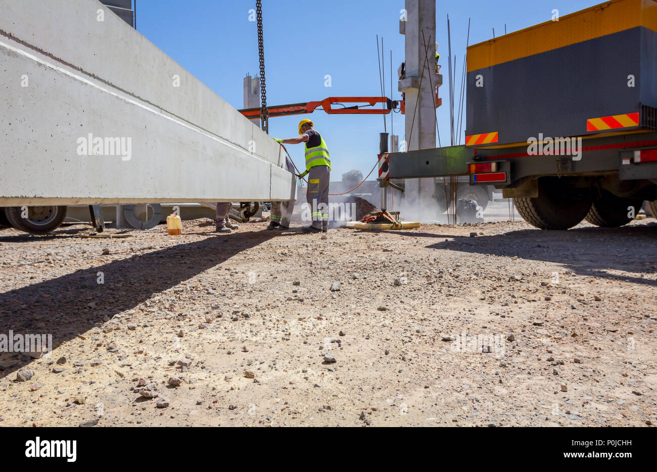 Worker is using abrasive grinding machine to set up concrete joist to ...