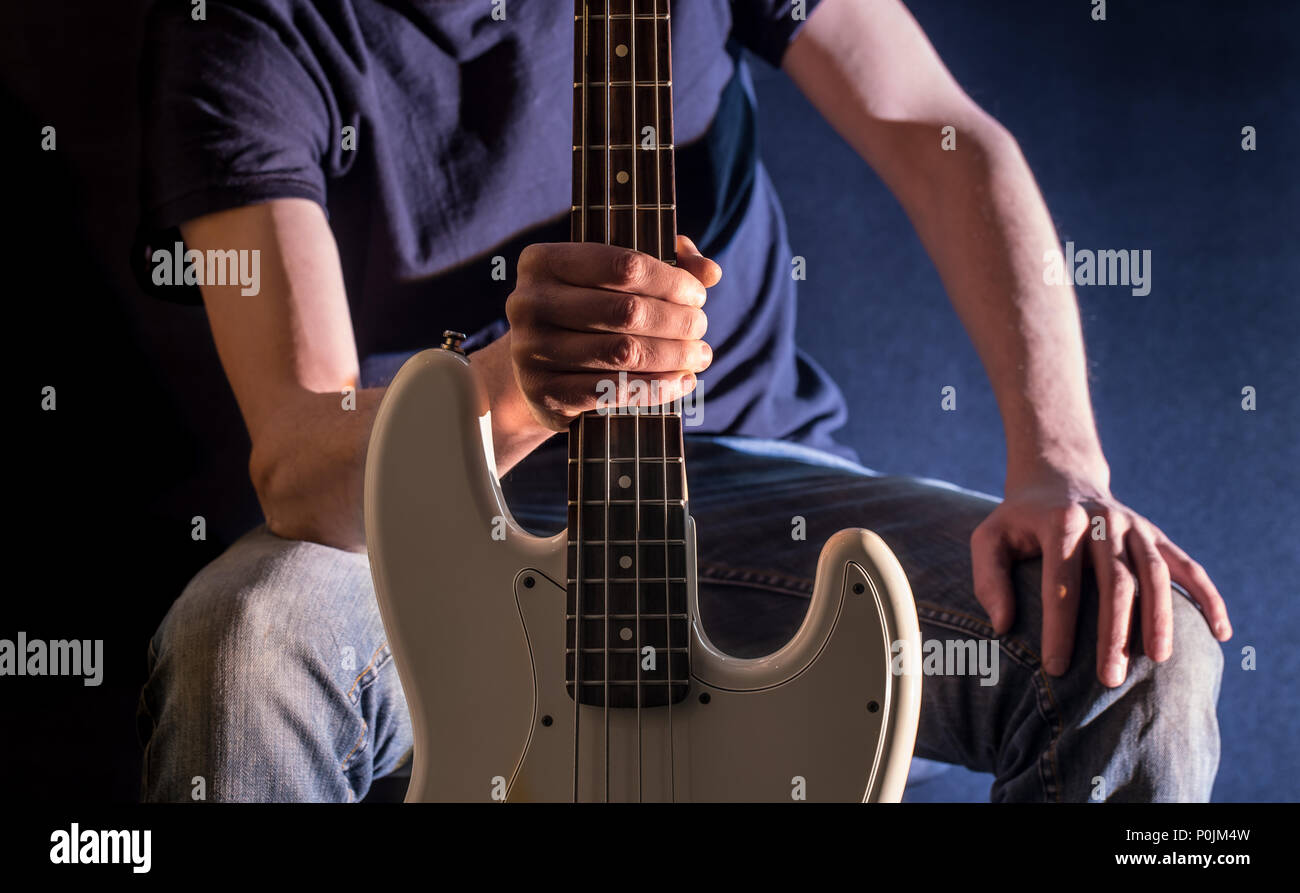 the man plays bass guitar on a black background, the music concept ...