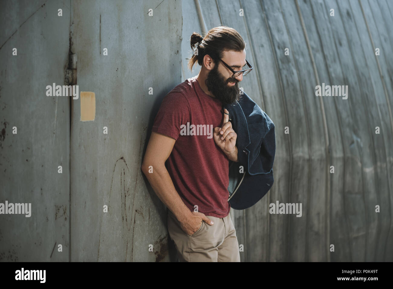 handsome young man leaning back on old hangar Stock Photo - Alamy