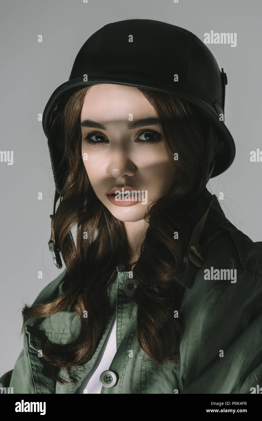 beautiful girl posing in military helmet with shadows on face, isolated ...