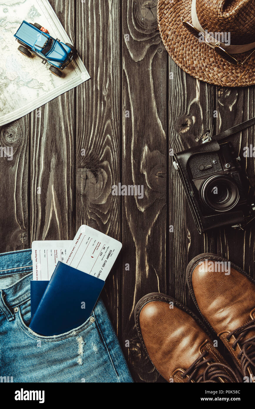 flat lay with denim pants, shoes, straw hat, retro photo camera ...