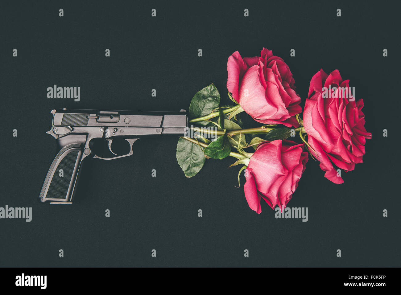 Bouquet of red roses shooting from gun isolated on black Stock Photo ...