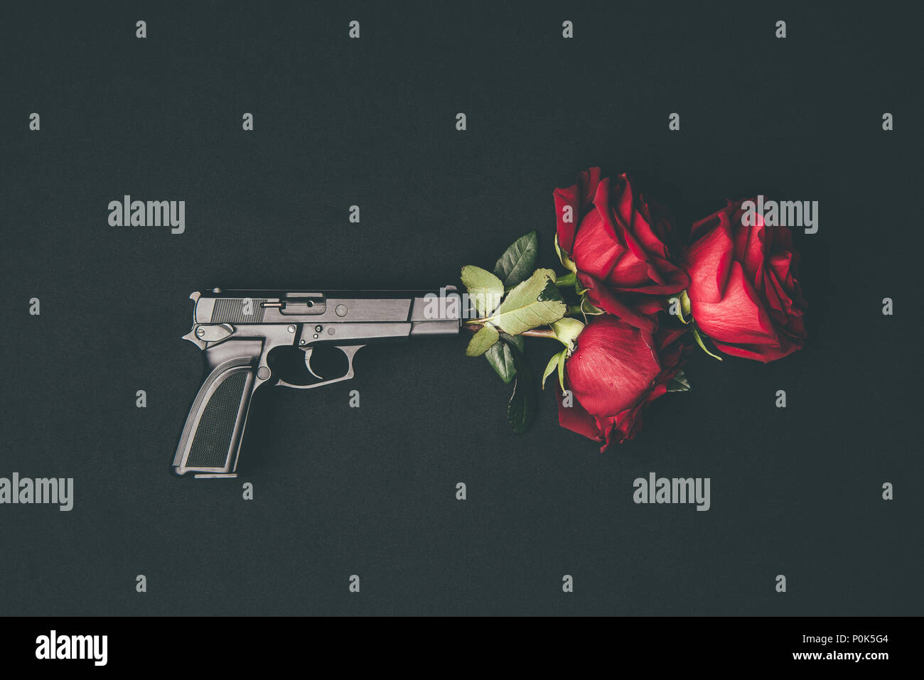 Red roses in gun barrel isolated on black Stock Photo - Alamy