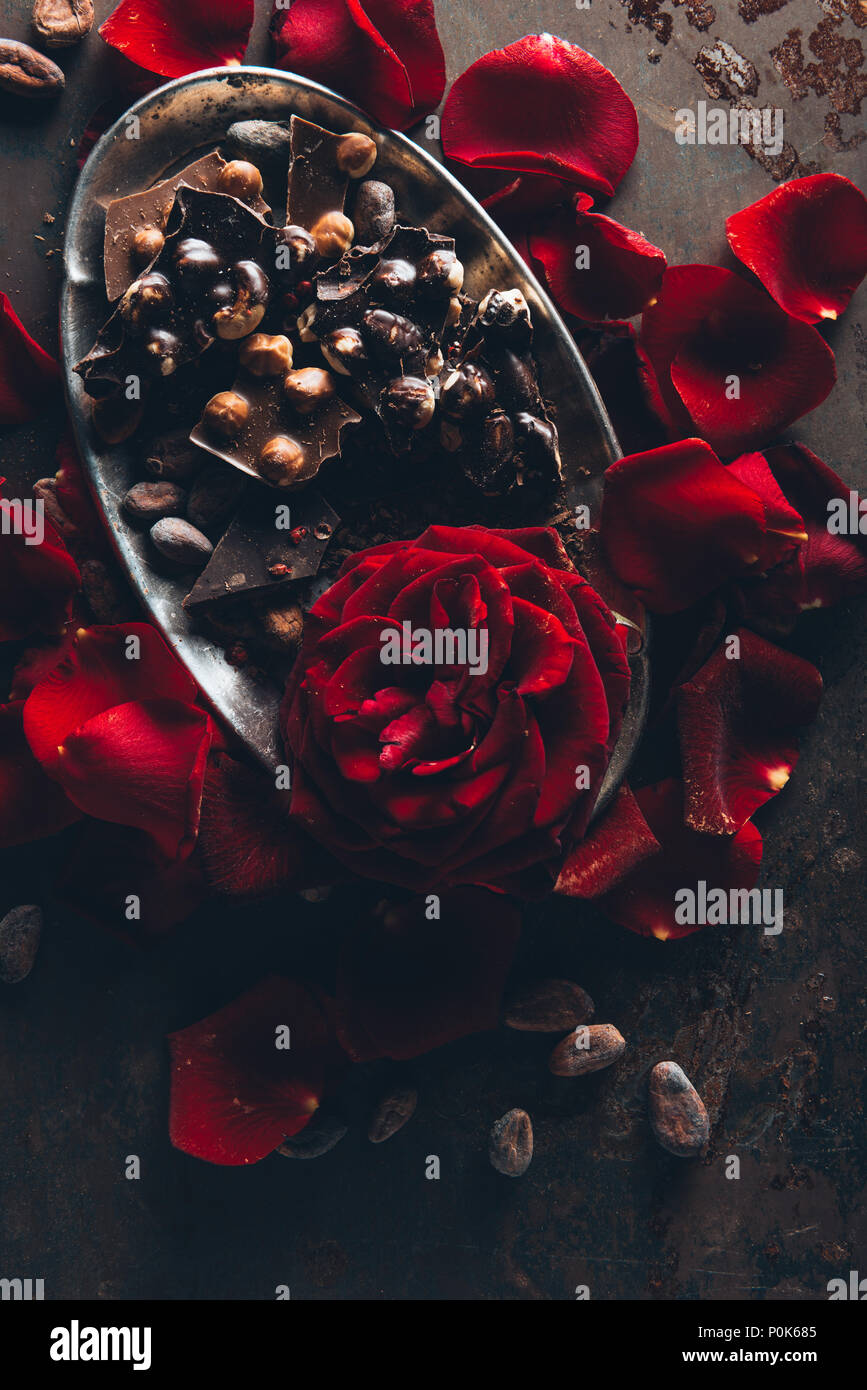top view of beautiful red rose petals and gourmet chocolate with ...