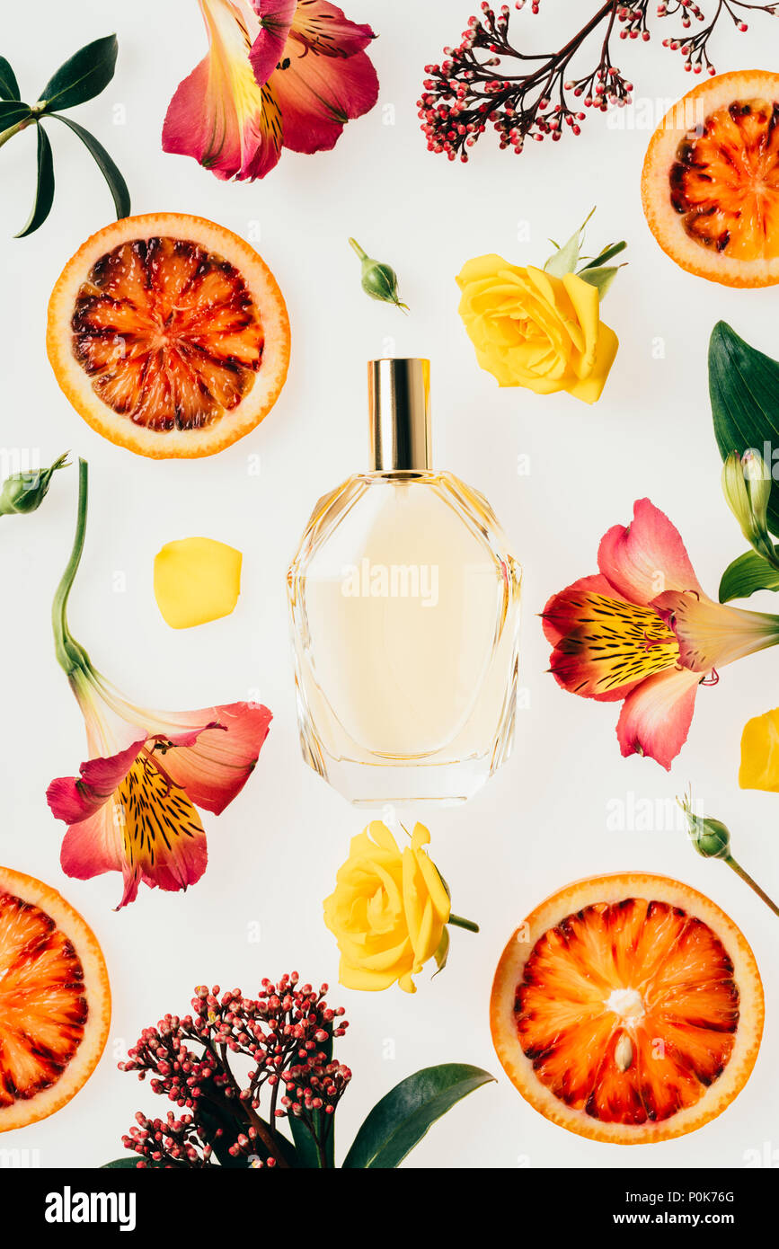 top view of bottle of aromatic perfume surrounded with flowers and ...