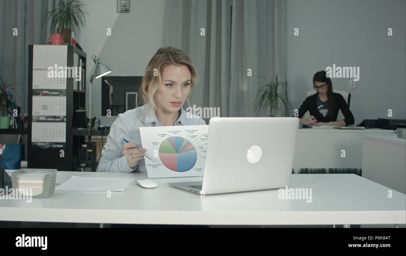 Office woman explaining pie chart to colleagues via laptop Stock Photo ...