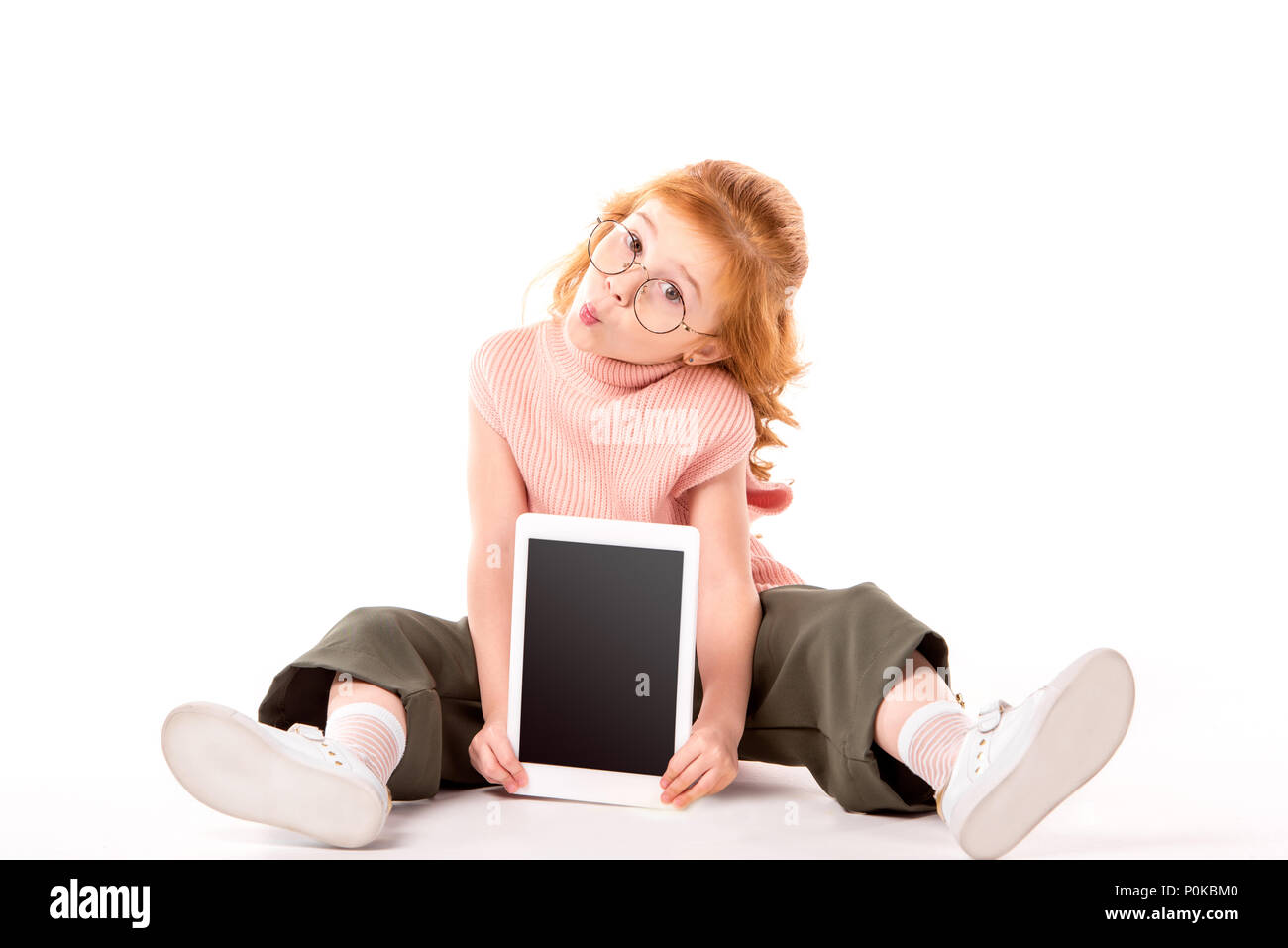 kid with ginger hair sitting and showing tablet on white Stock Photo ...