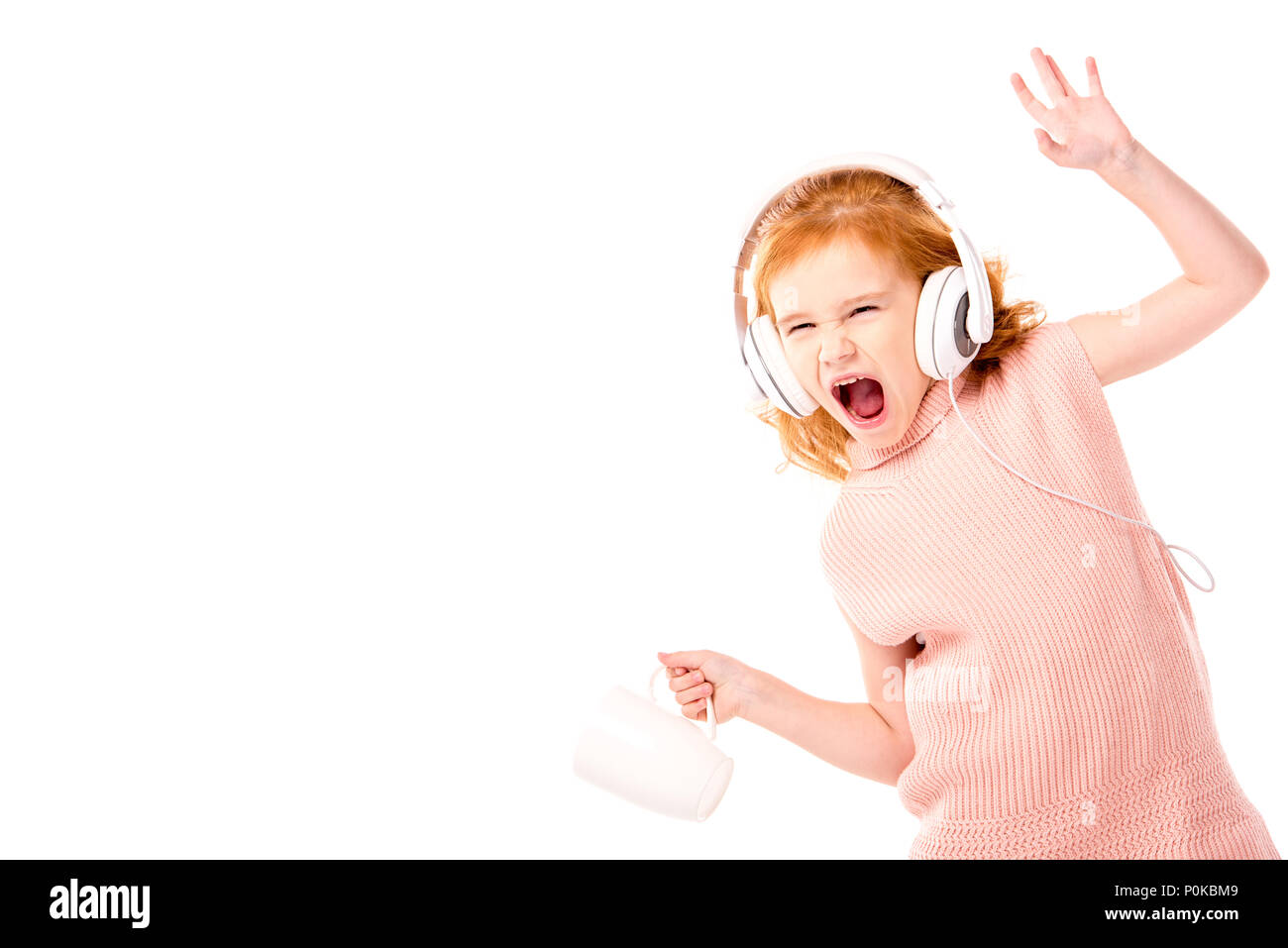 red hair kid in headphones screaming and dancing with cup isolated on ...
