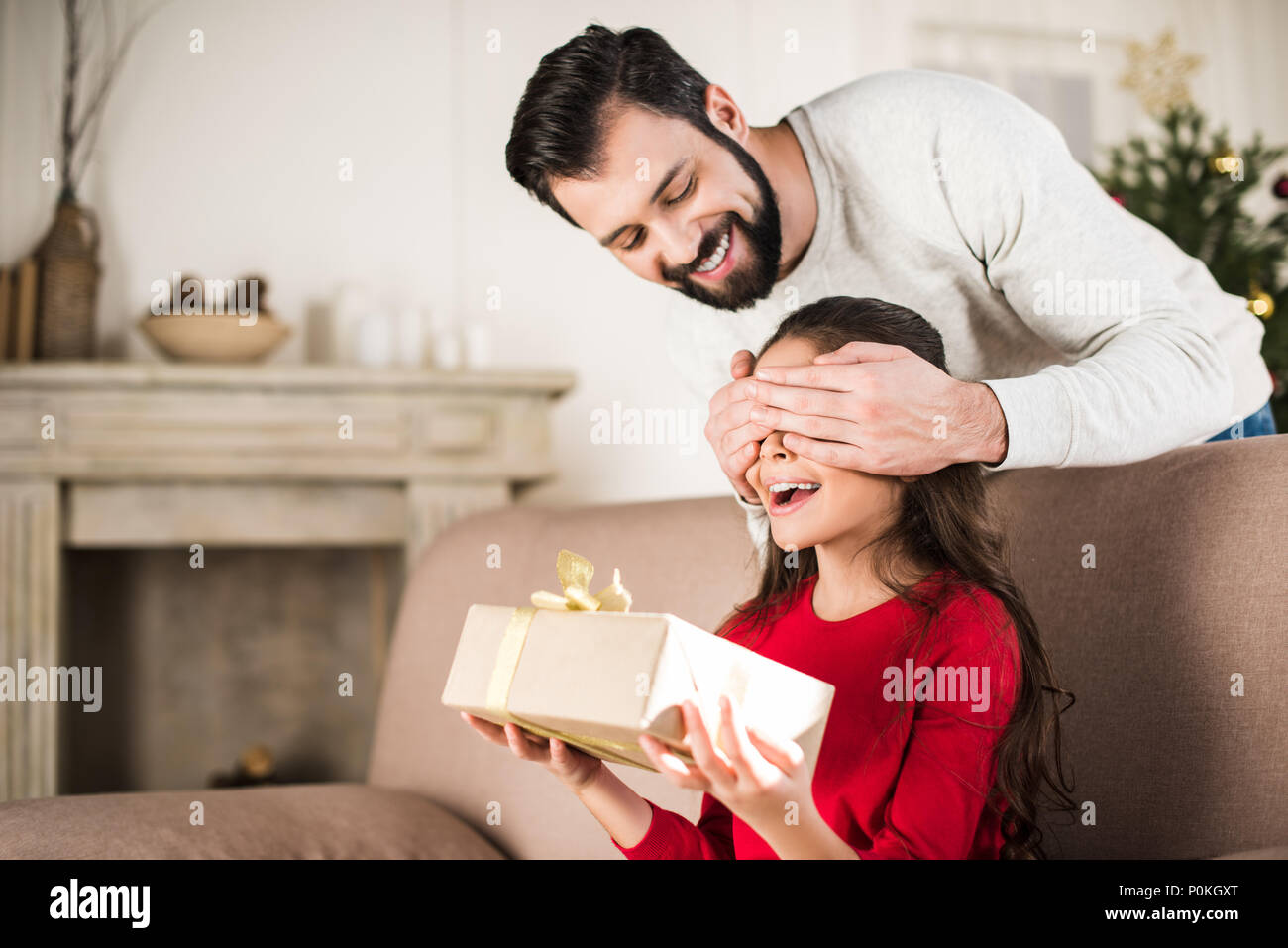 father covering daughter eyes from back and presenting gift Stock Photo ...