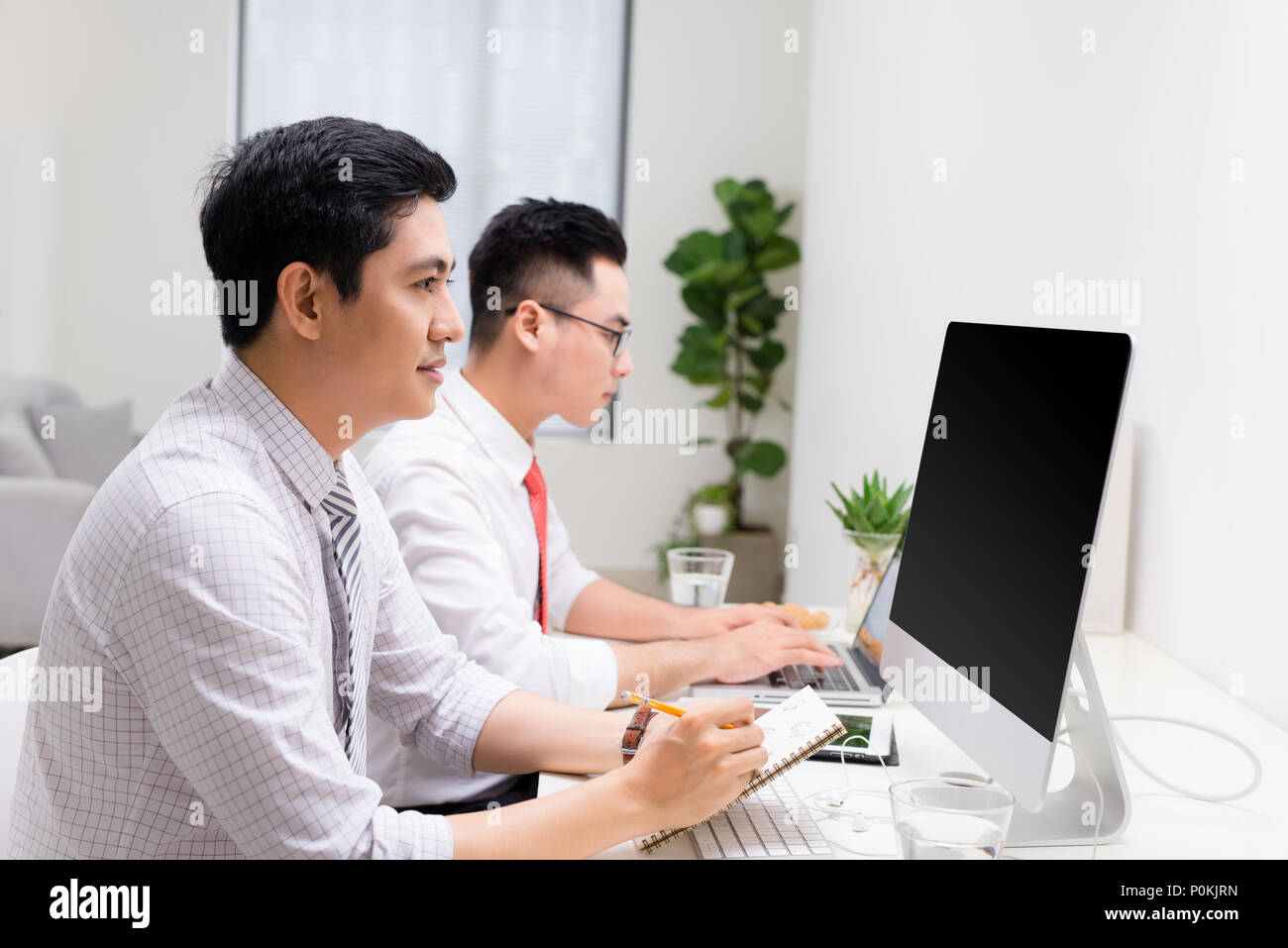 Two successful businessmen sitting computer hi-res stock photography ...