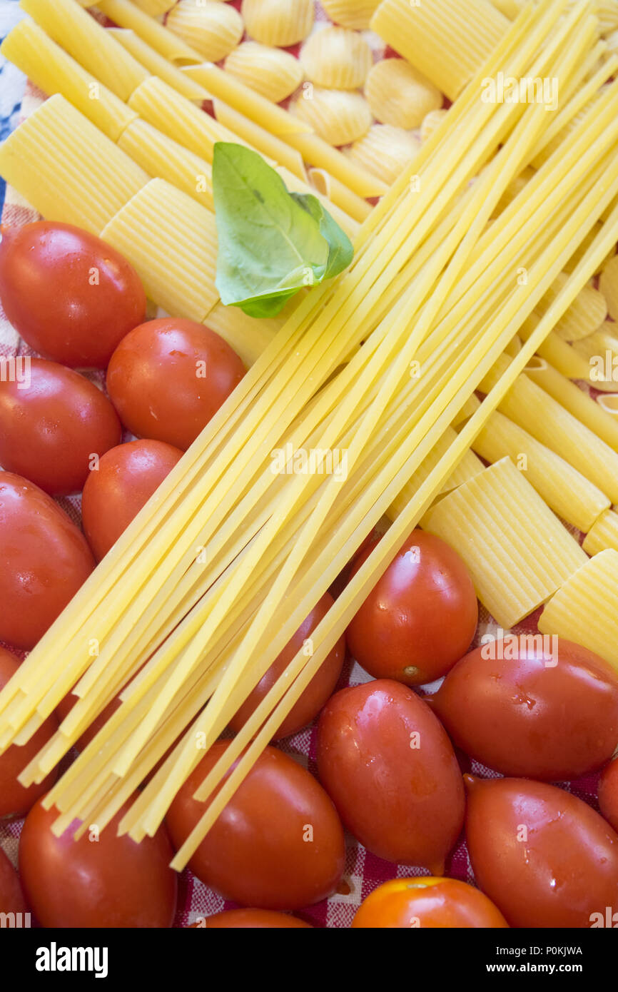 raw assorted pasta with fresh tomatoes and basil Stock Photo - Alamy