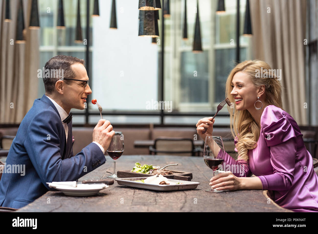 side view of beautiful adult couple eating at luxury restaurant Stock ...