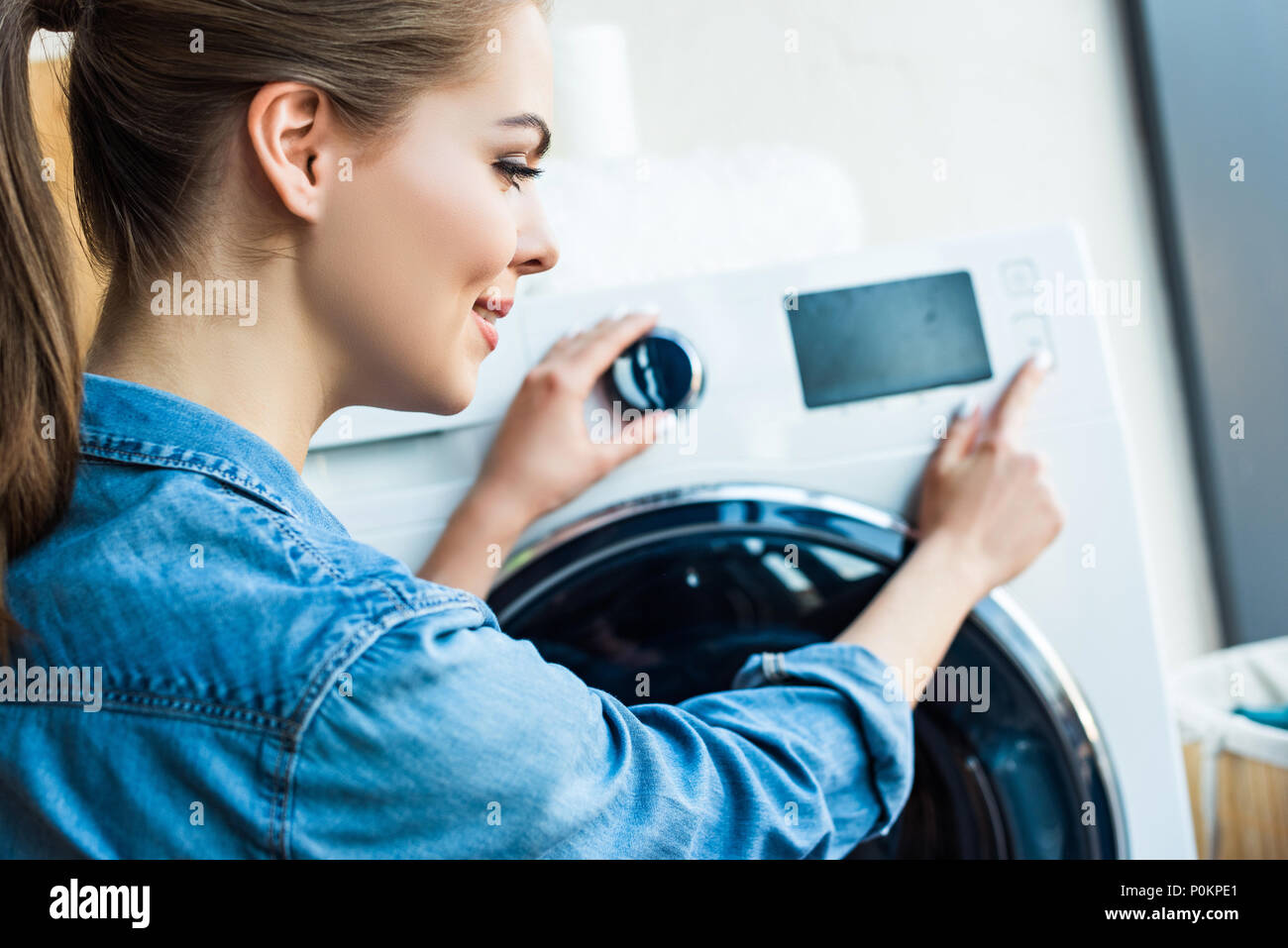beautiful smiling young woman using washing machine at home Stock Photo ...