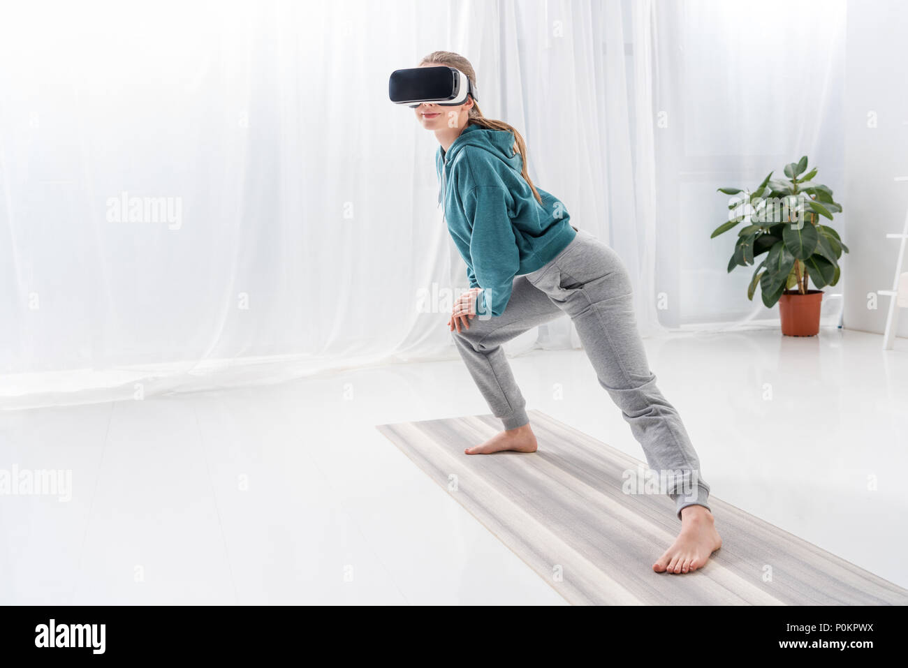 girl stretching legs with vr headset on yoga mat at home Stock Photo ...