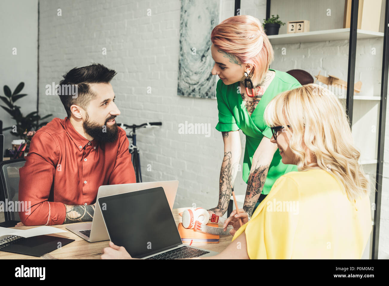 group of young creative workers discussing new project together in ...