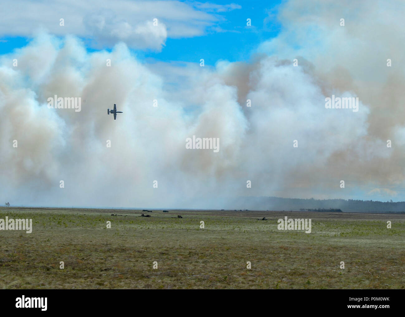 An A-10 Thunderbolt II flies past a plume of smoke during Saber Strike ...