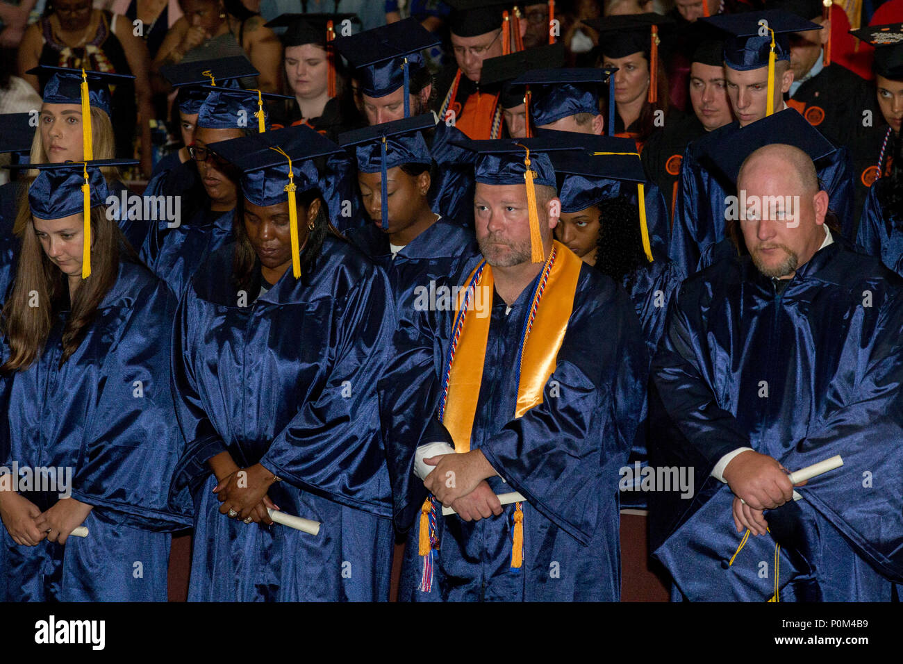 Graduates bow their heads as the invocation is given during the ...