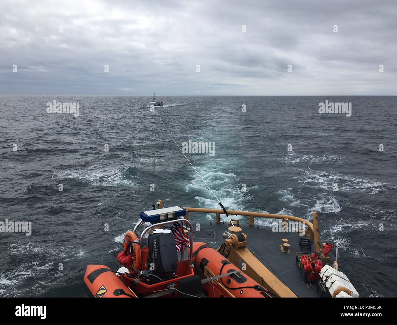The crew of the Coast Guard Cutter Naushon tows four mariners after the ...