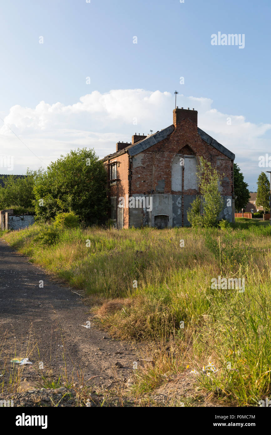 Derelict buildings awaiting demolition in sunset light with a blue sky ...