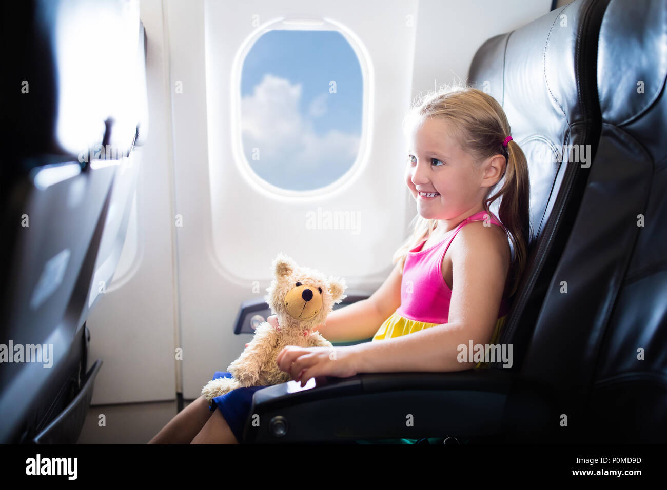 Child in airplane. Kid in air plane sitting in window seat. Flight ...