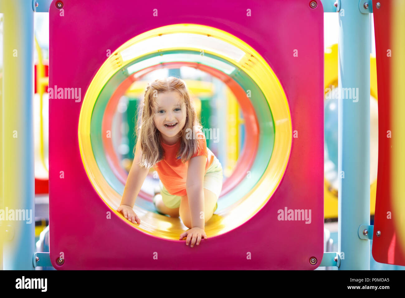 Kids climbing and sliding on outdoor playground. Children play in sunny ...