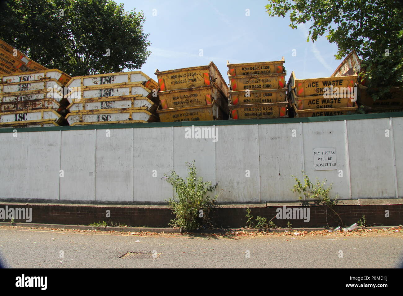 'No Fly-Tipping' Sign in front on pile of Skips Stock Photo - Alamy