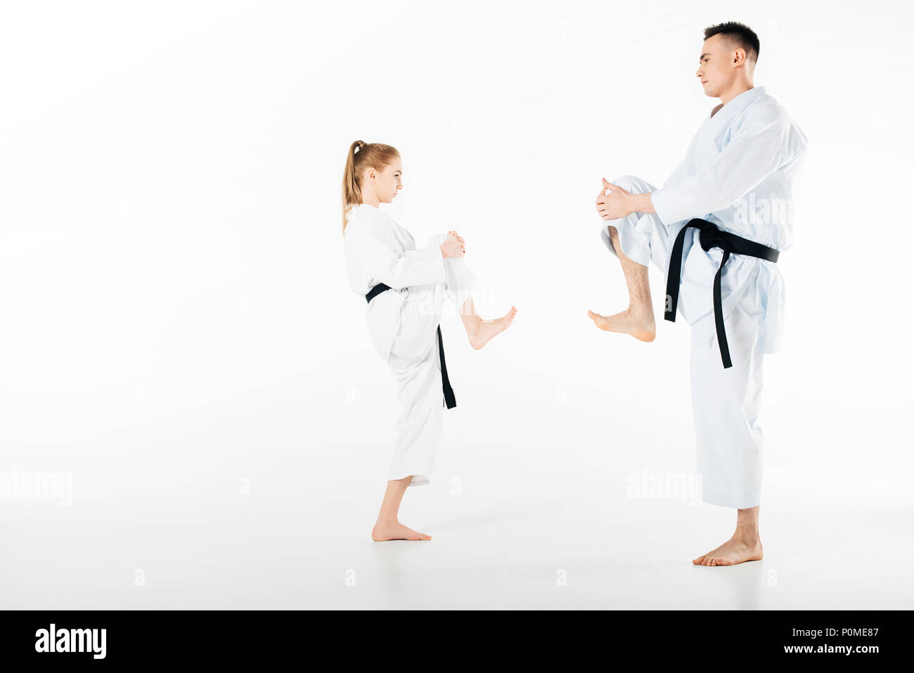 side view of karate fighters stretching legs isolated on white Stock ...