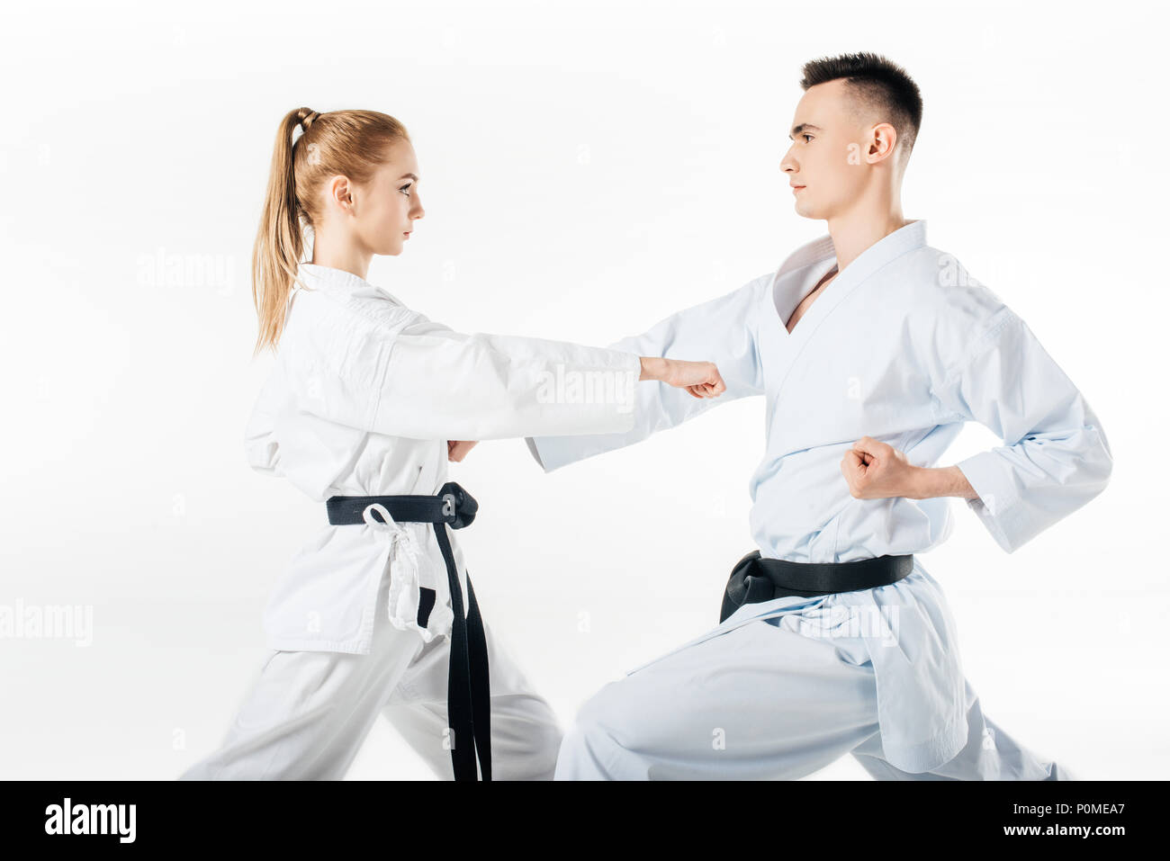 side view of karate fighters exercising in kimono isolated on white ...