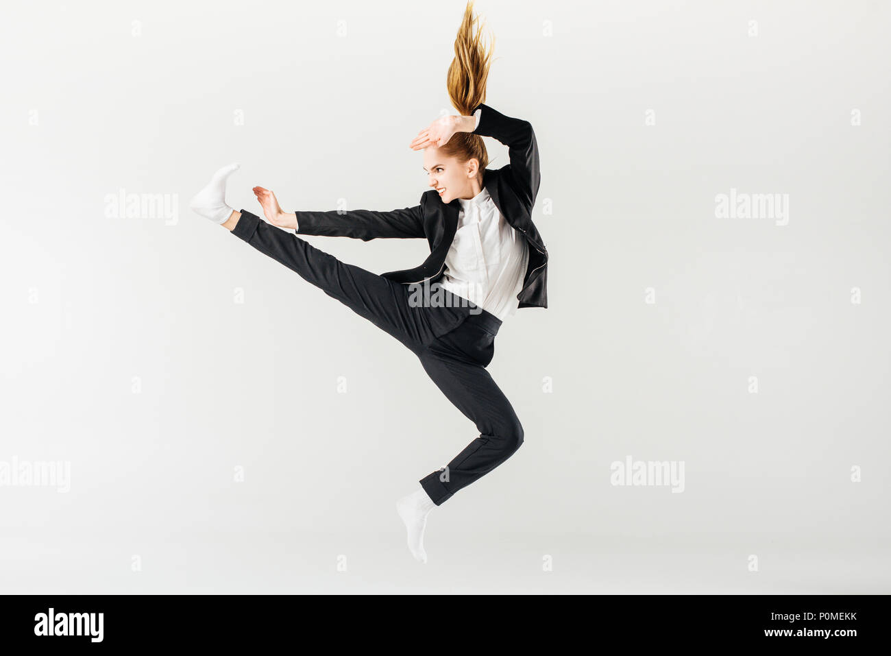 female karate fighter jumping and performing kick in suit isolated on ...