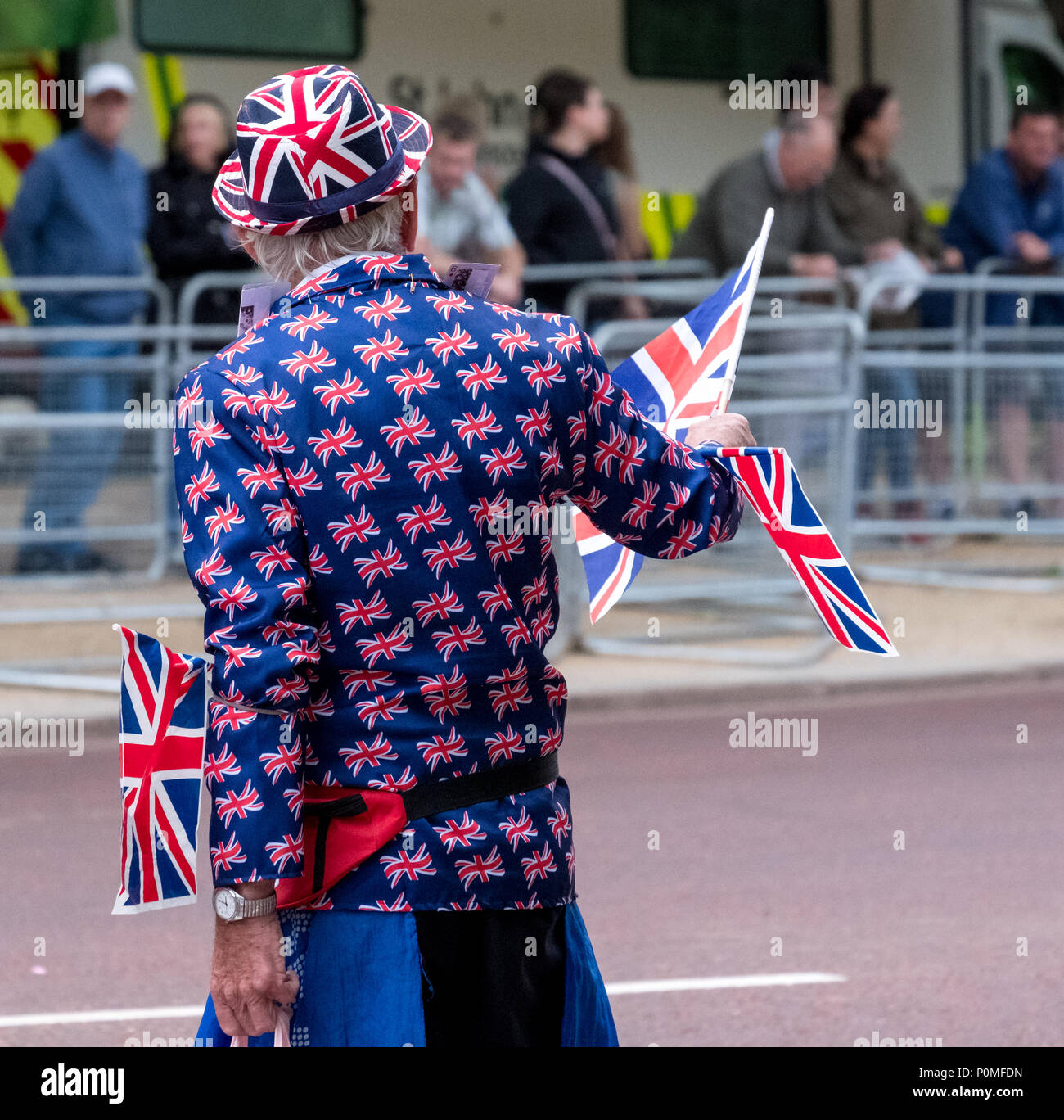 Man dressed in jacket and hat decorated with union jack flags, and ...