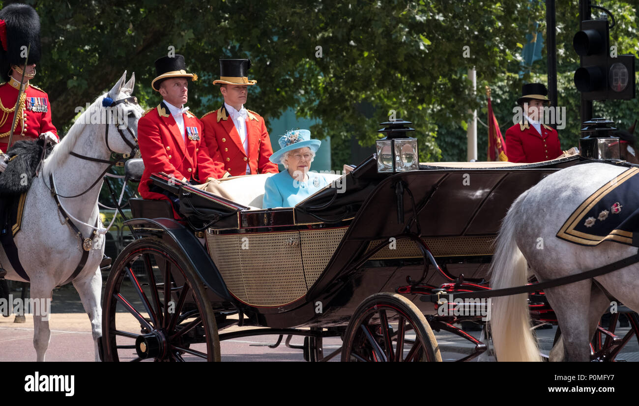 Queen Elizabeth II travels along The Mall in an open carriage pulled by ...